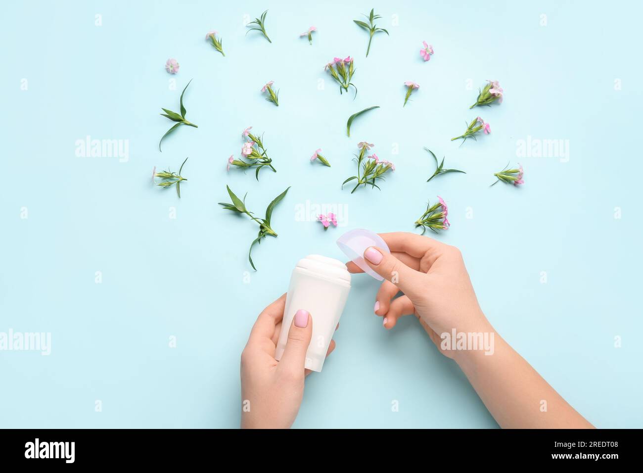 Female hands holding deodorant on blue background Stock Photo - Alamy