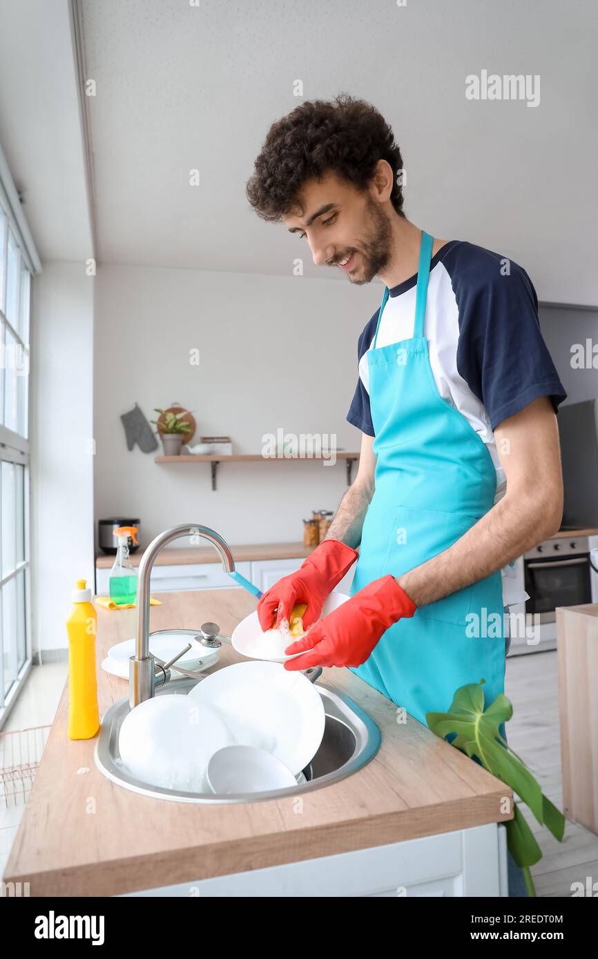 Young man washing dishes in kitchen Stock Photo - Alamy