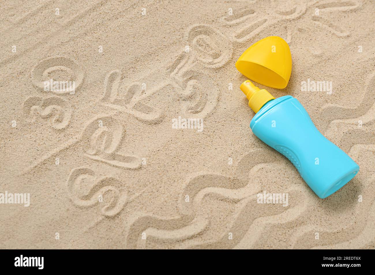 Creative composition with sunscreen cream and drawings on sand Stock ...