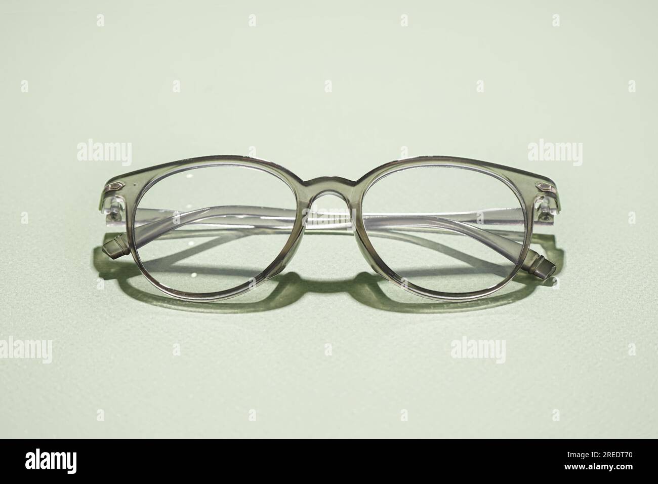 Stylish grey eyeglasses on pale green background Stock Photo - Alamy
