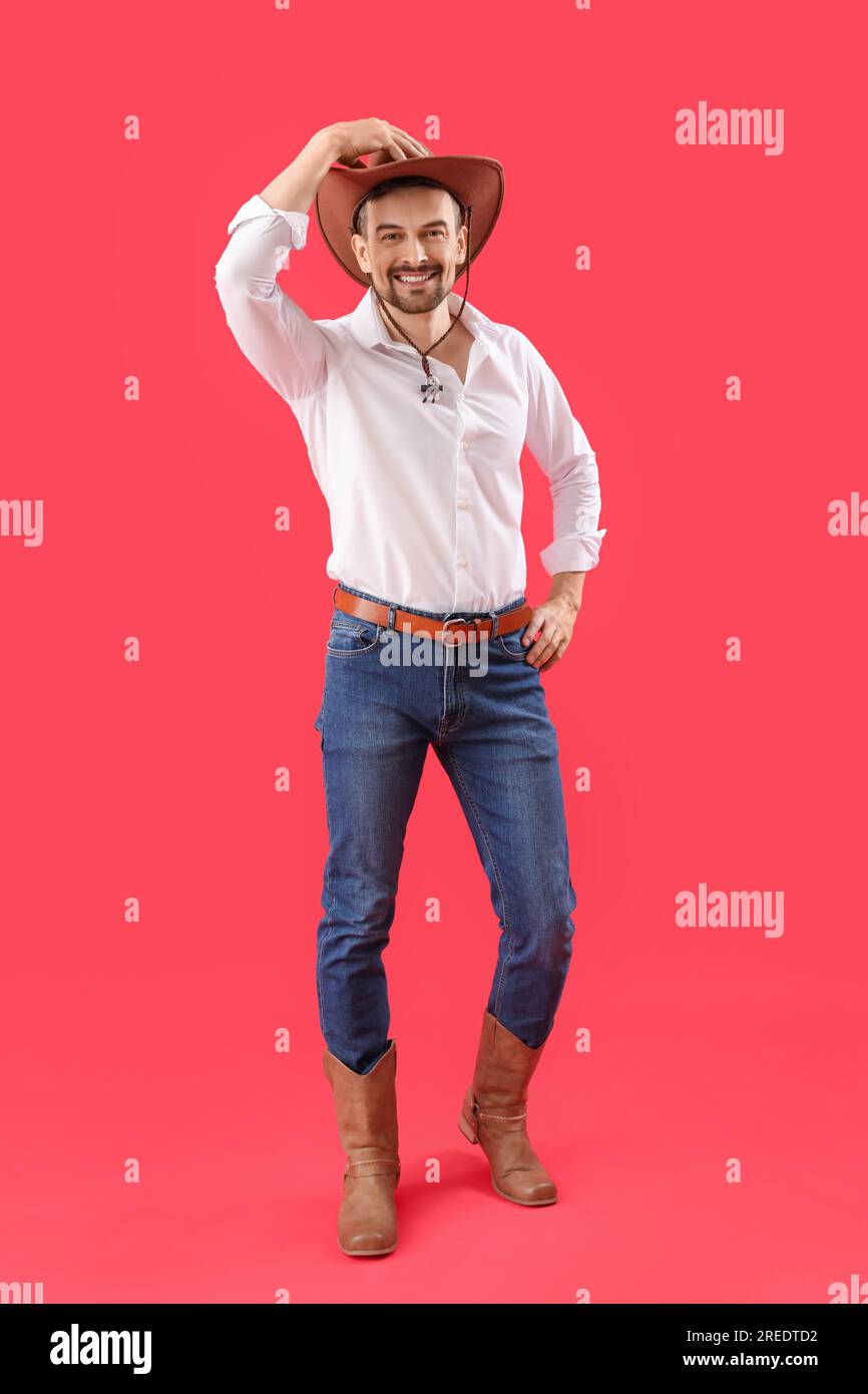 Handsome cowboy on red background Stock Photo - Alamy