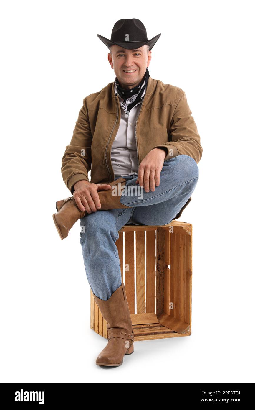 Mature cowboy sitting on white background Stock Photo - Alamy