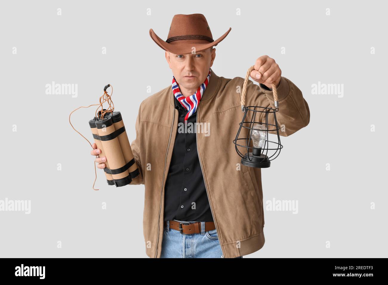 Mature cowboy with explosive and lantern on light background Stock ...