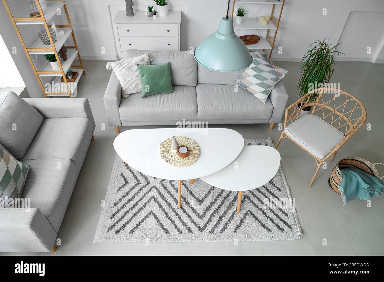 Interior of light living room with plants, sofas and coffee tables, top ...