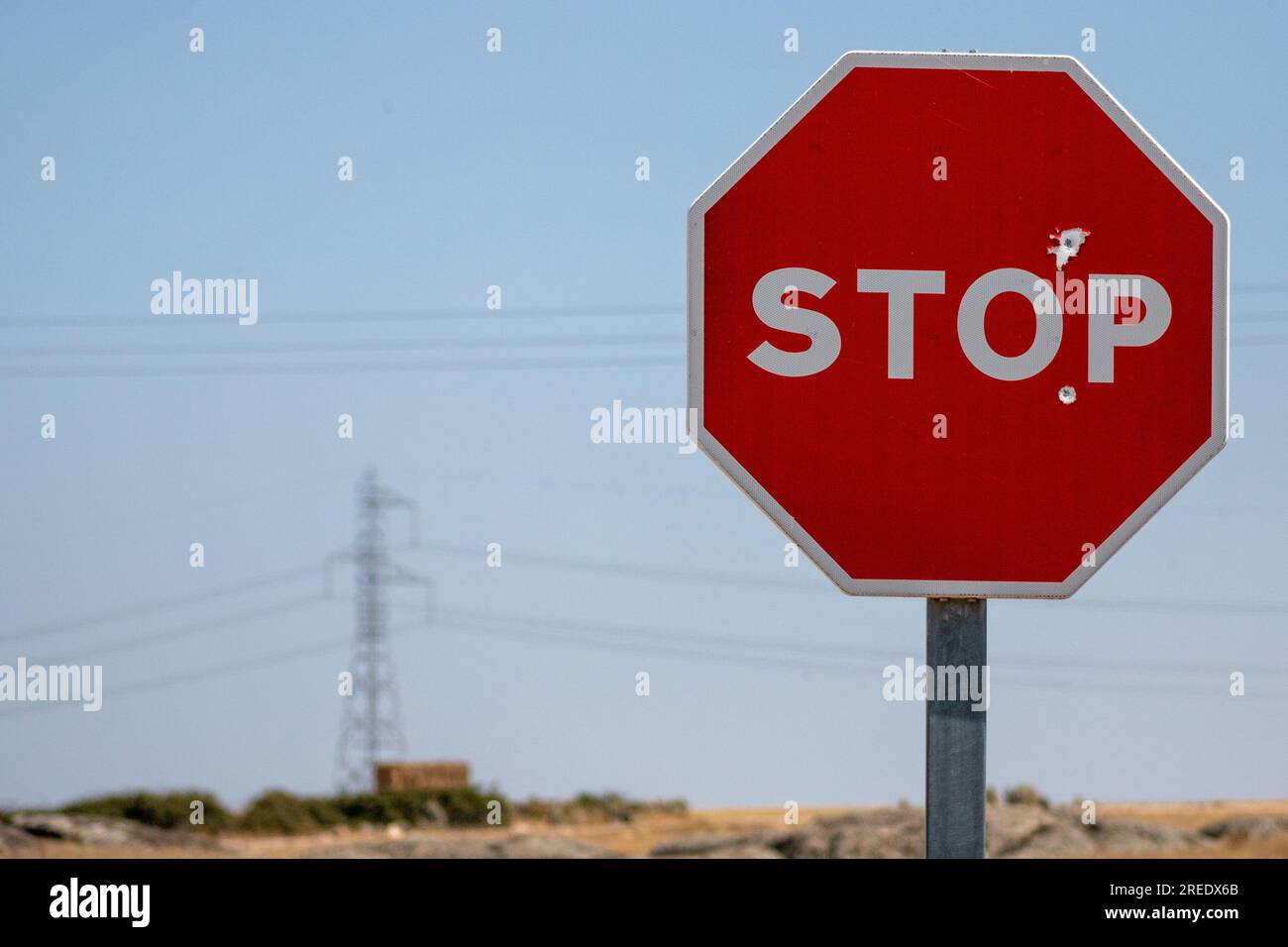 Stop sign, which has been shot with a firearm, in the background you ...