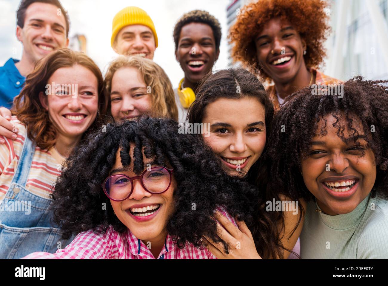 Happy playful multiethnic group of young friends bonding outdoors ...