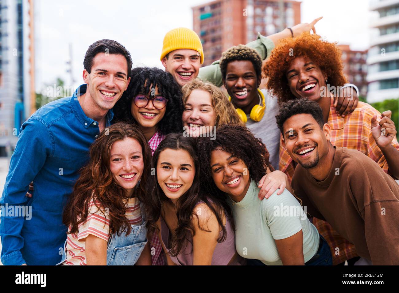 Happy playful multiethnic group of young friends bonding outdoors ...