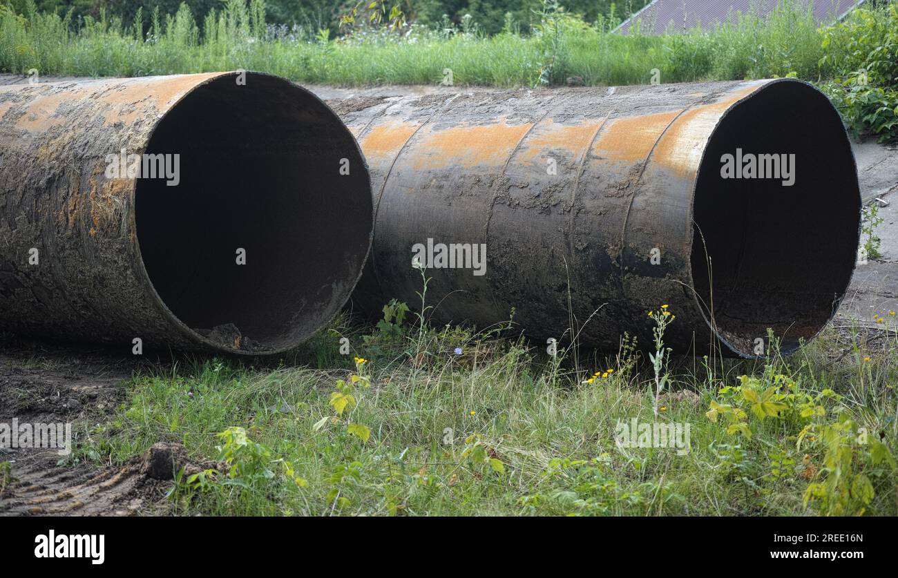 Two rusty old pipes laying on grass. Close up Stock Photo - Alamy