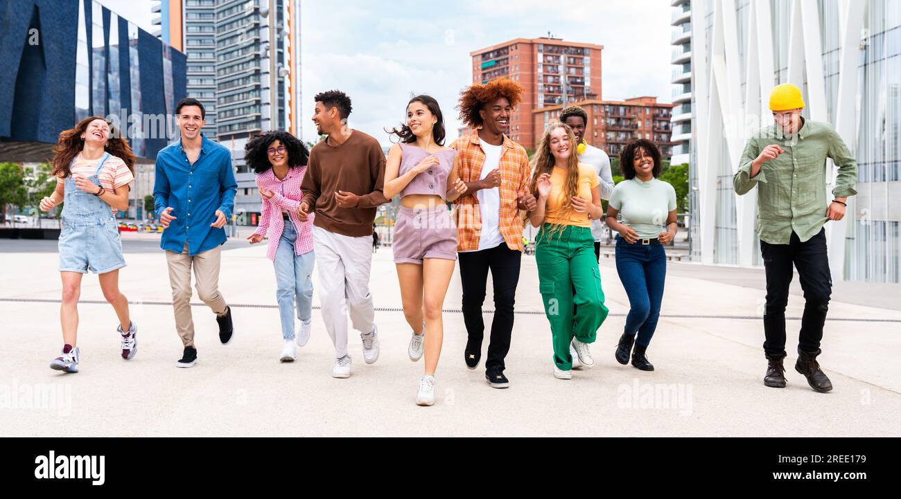 Happy playful multiethnic group of young friends bonding outdoors ...