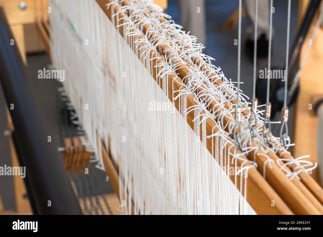 Close-up of a floor loom warp threads and heddles for textile weaving ...