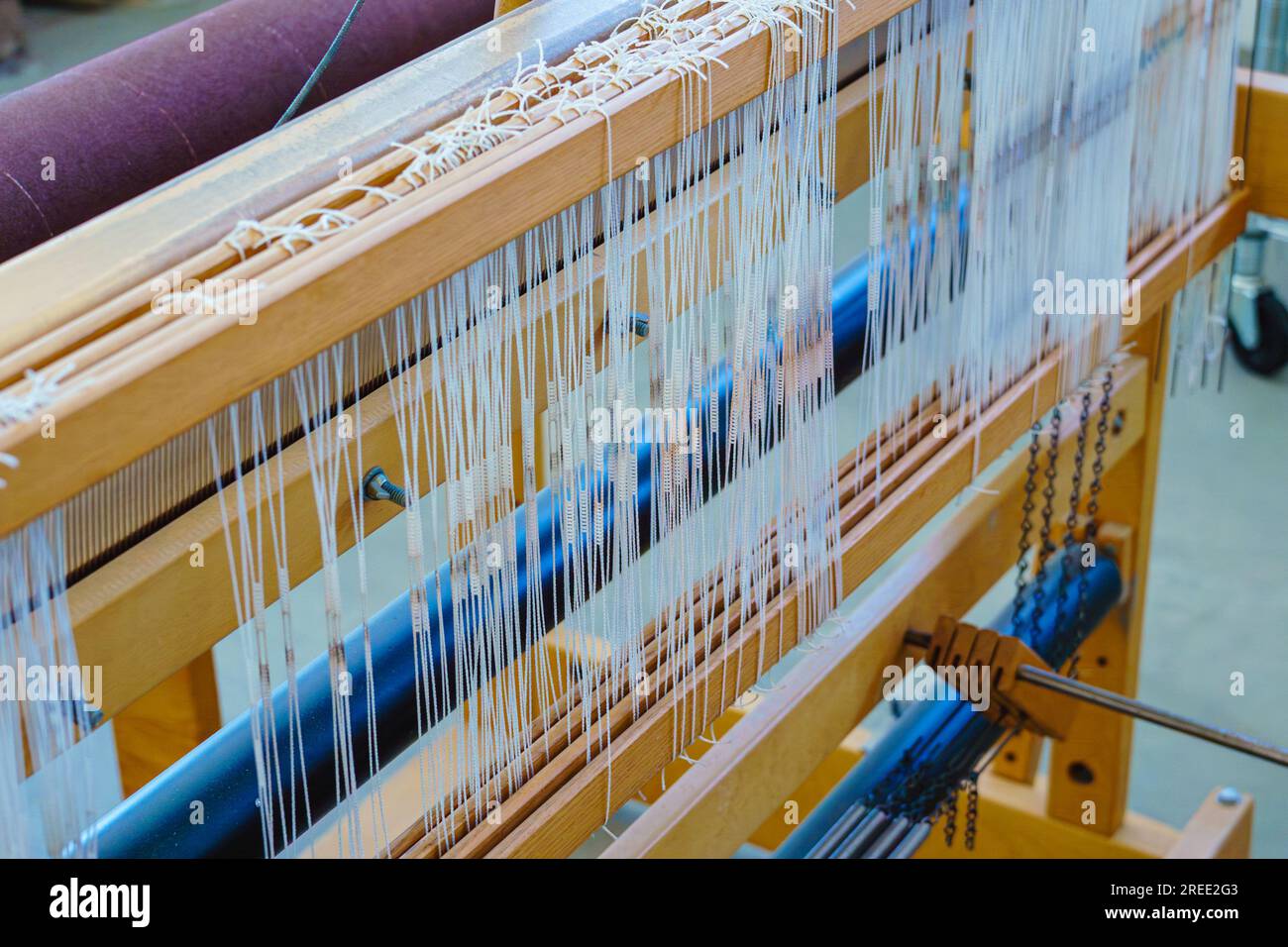 Close-up of a floor loom warp threads and heddles for textile weaving ...