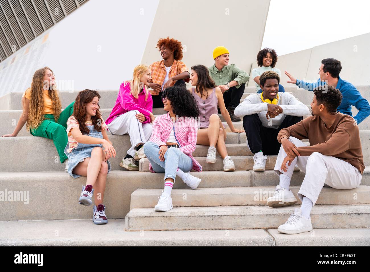 Happy playful multiethnic group of young friends bonding outdoors ...