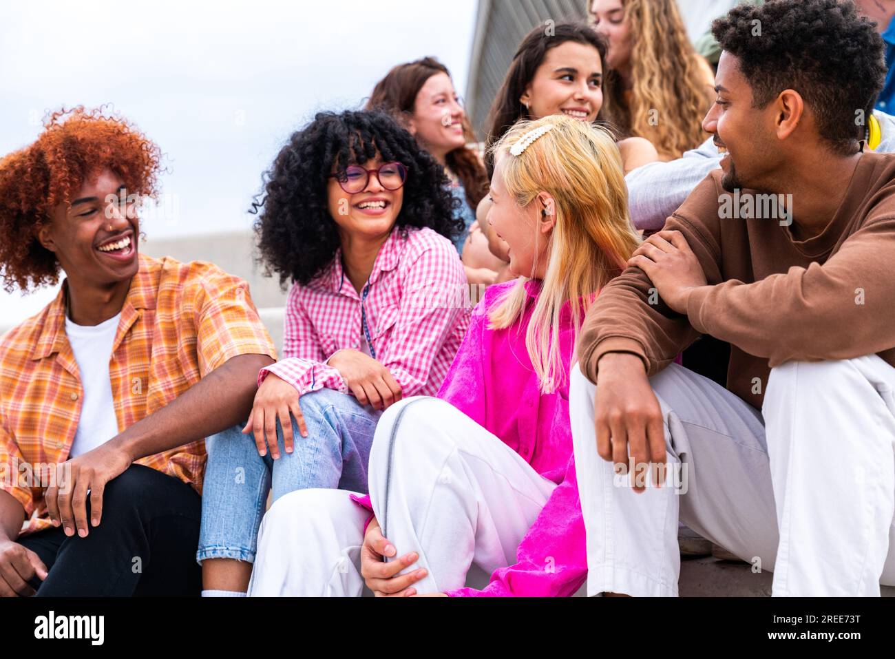 Happy playful multiethnic group of young friends bonding outdoors ...