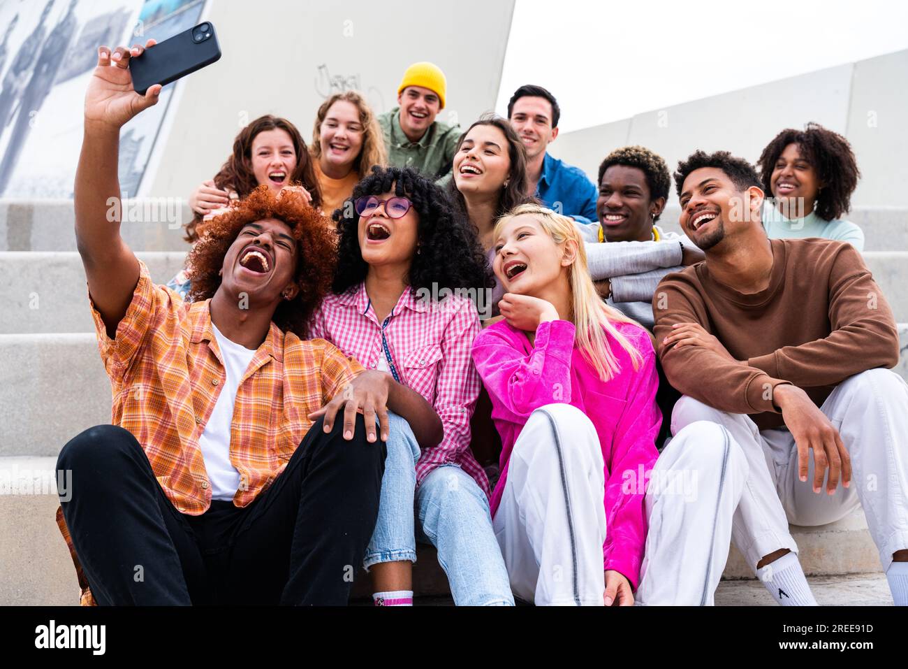 Happy playful multiethnic group of young friends bonding outdoors ...