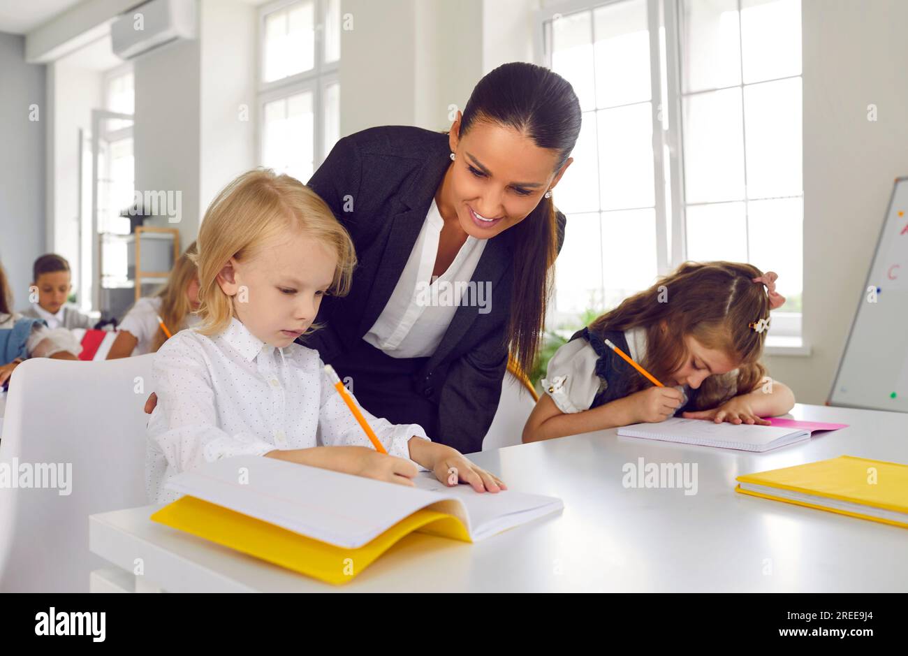 Teacher helping elementary school student boy with his task Stock Photo ...