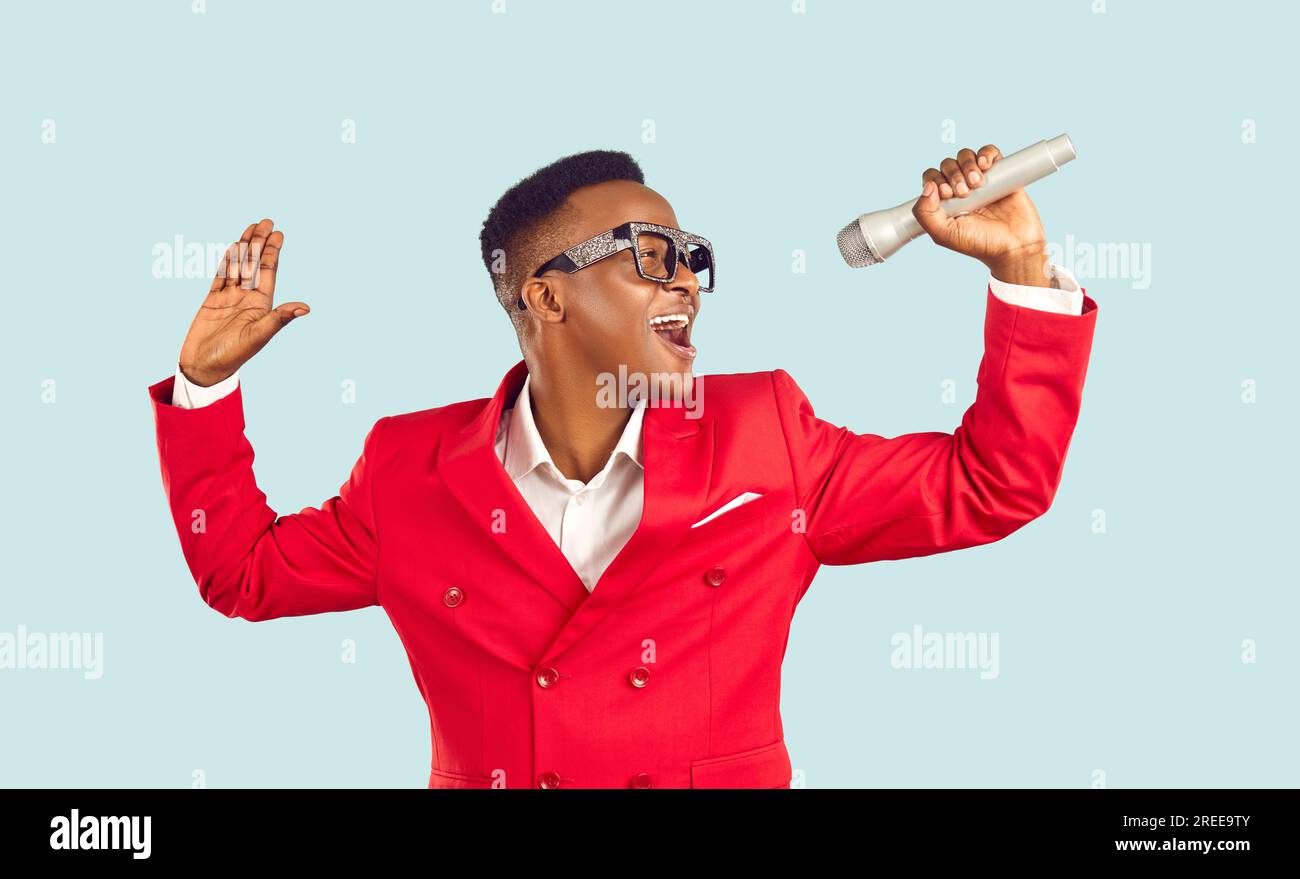 Extravagant man in suit singing song in microphone while performing on ...