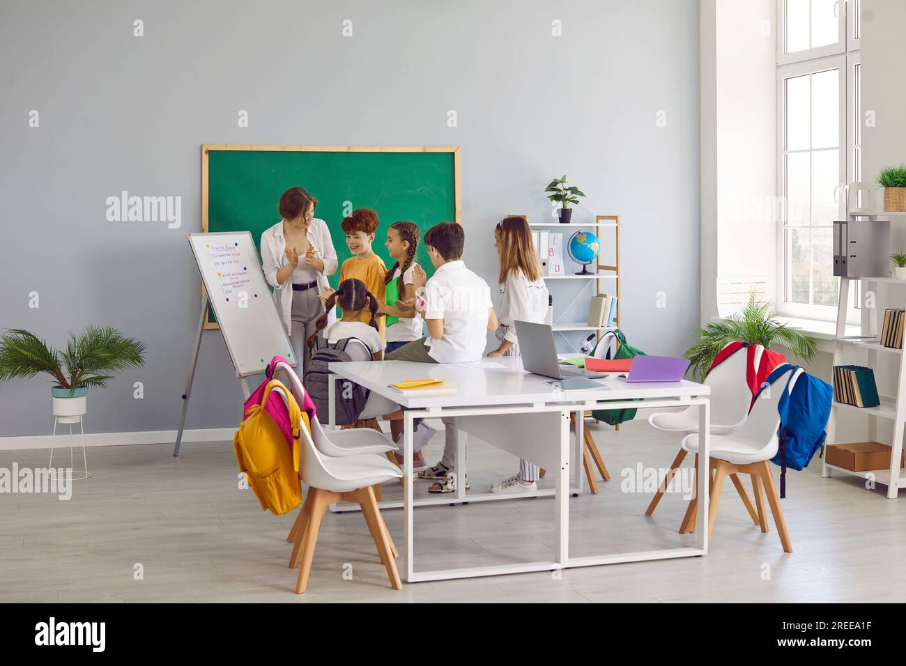 Happy children at private school take turns answering tasks of young ...