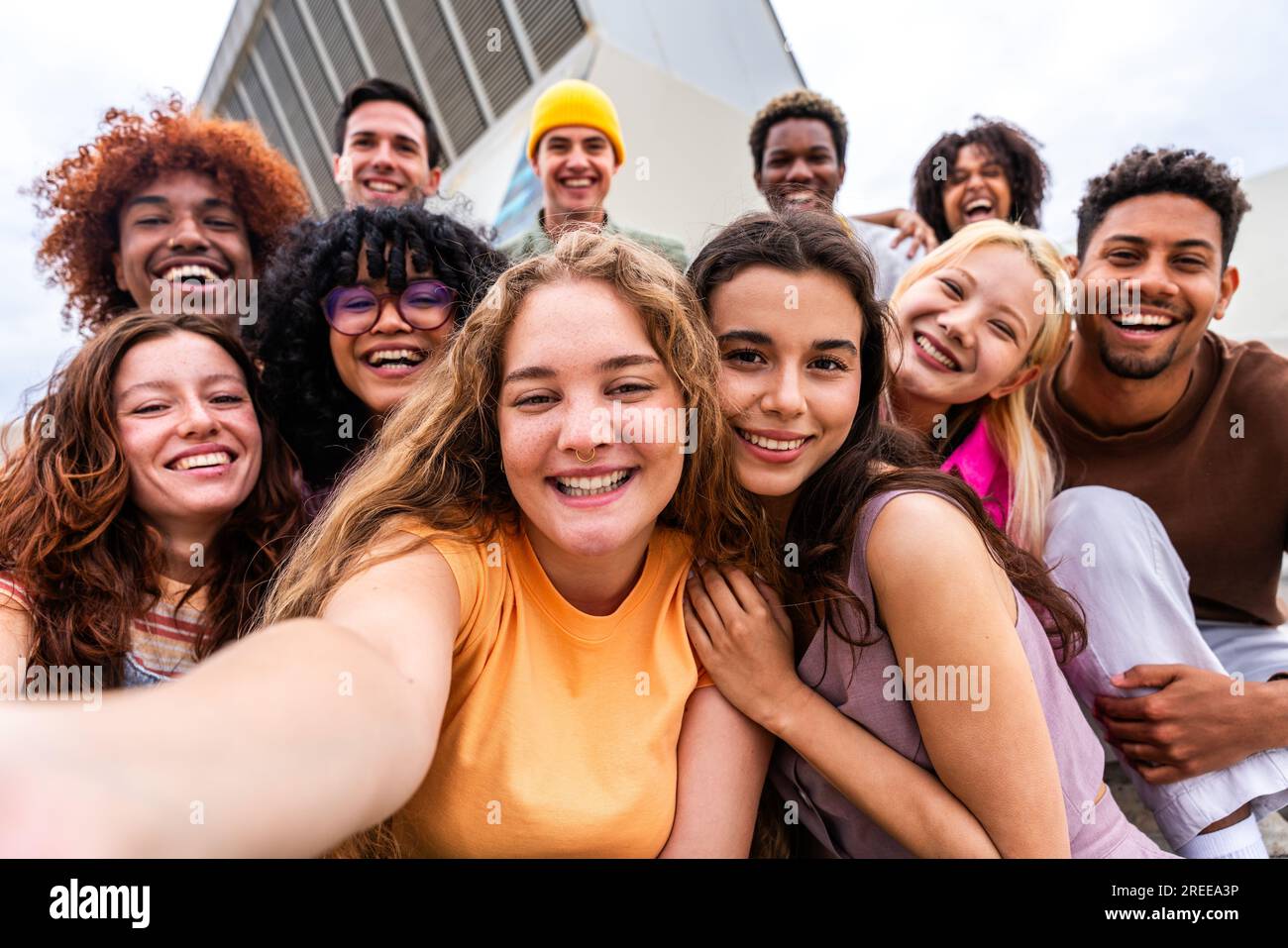 Happy playful multiethnic group of young friends bonding outdoors ...