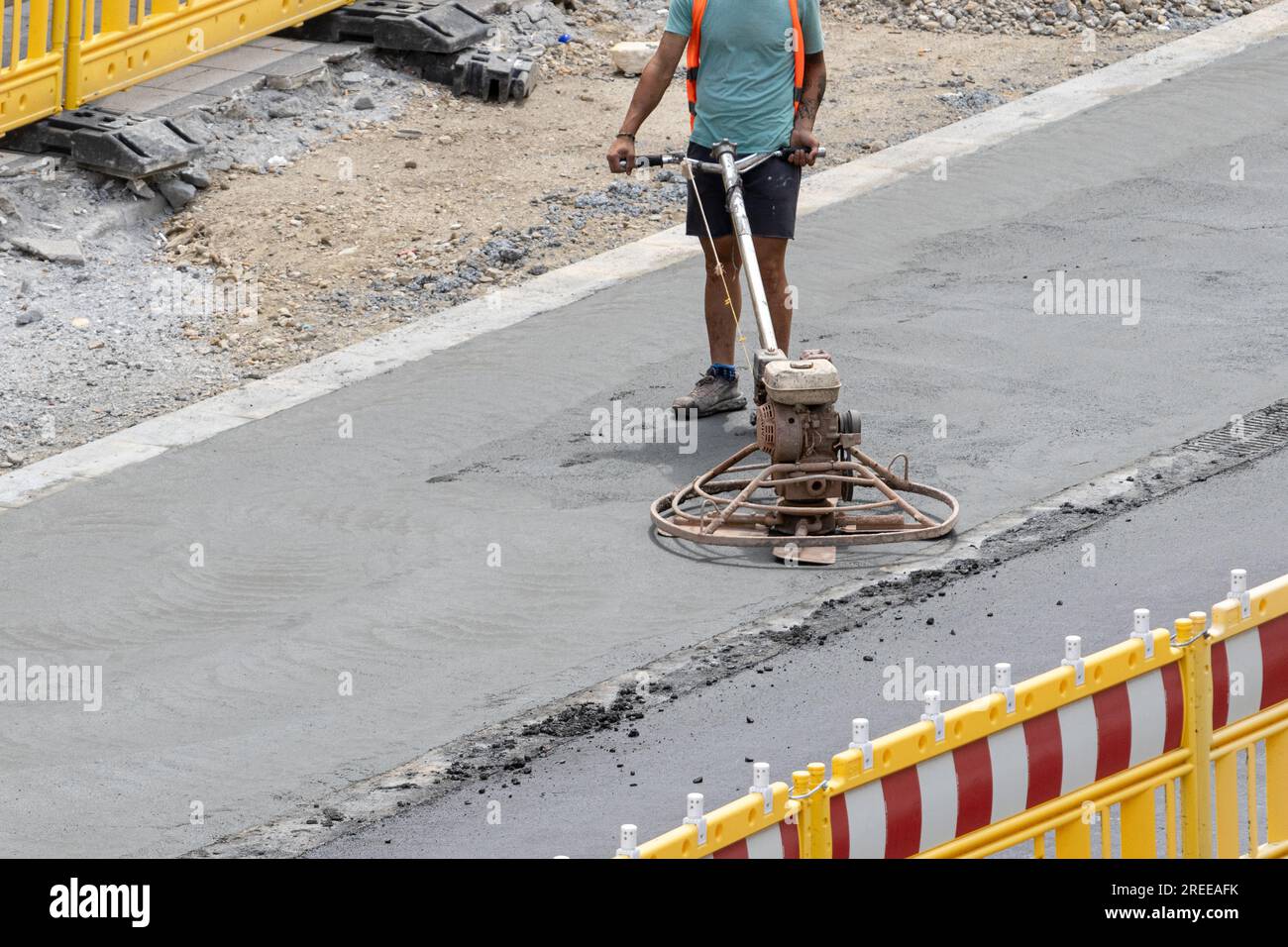 Worker using a machine to polishing concrete surface on a city road ...