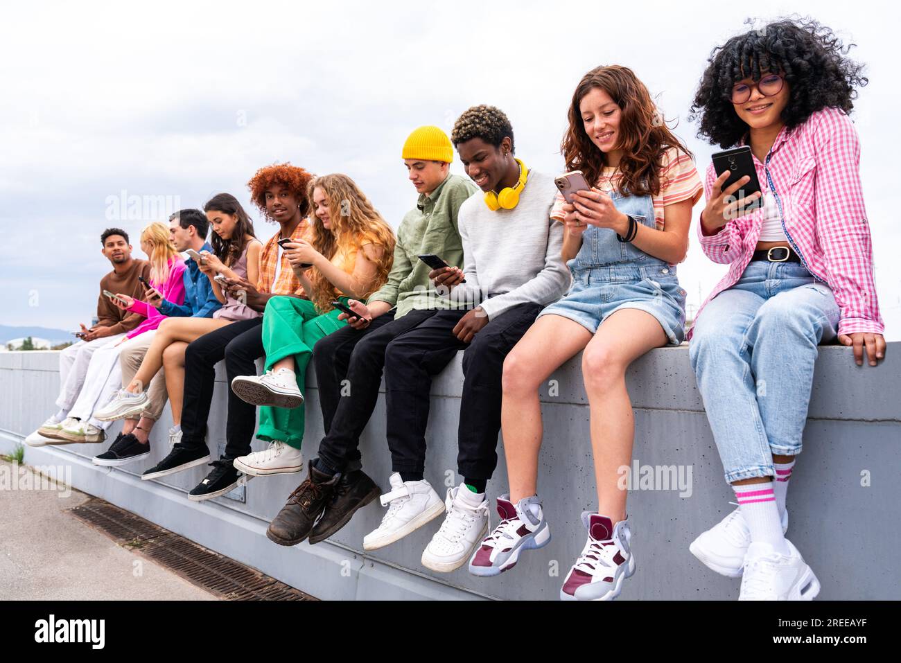 Happy playful multiethnic group of young friends bonding outdoors ...