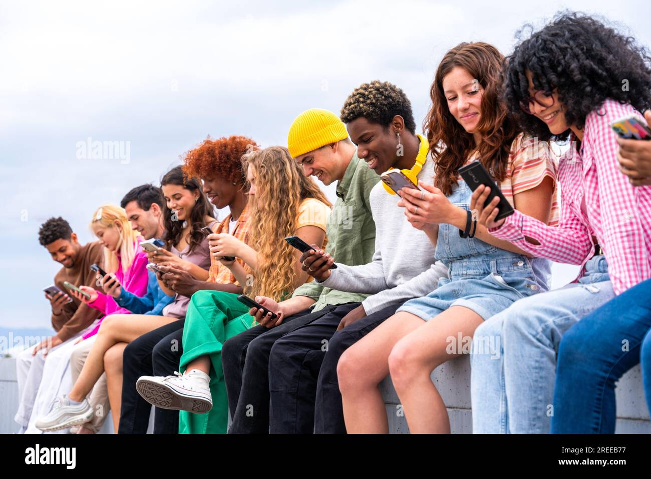 Happy playful multiethnic group of young friends bonding outdoors ...
