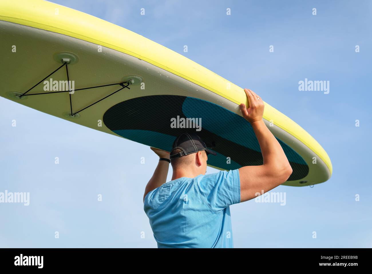 A professional surfer with a surfboard who carries the board over his ...