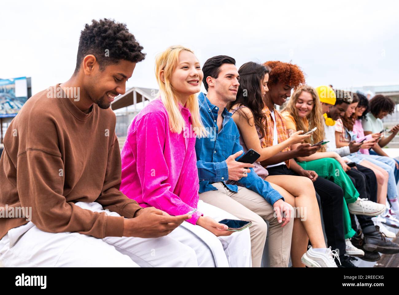 Happy playful multiethnic group of young friends bonding outdoors ...