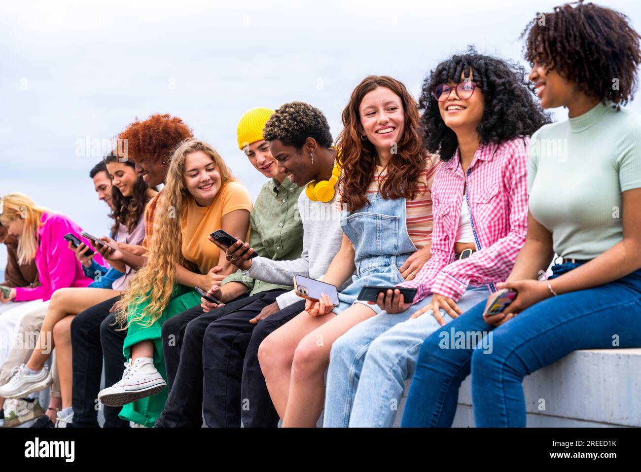 Happy playful multiethnic group of young friends bonding outdoors ...