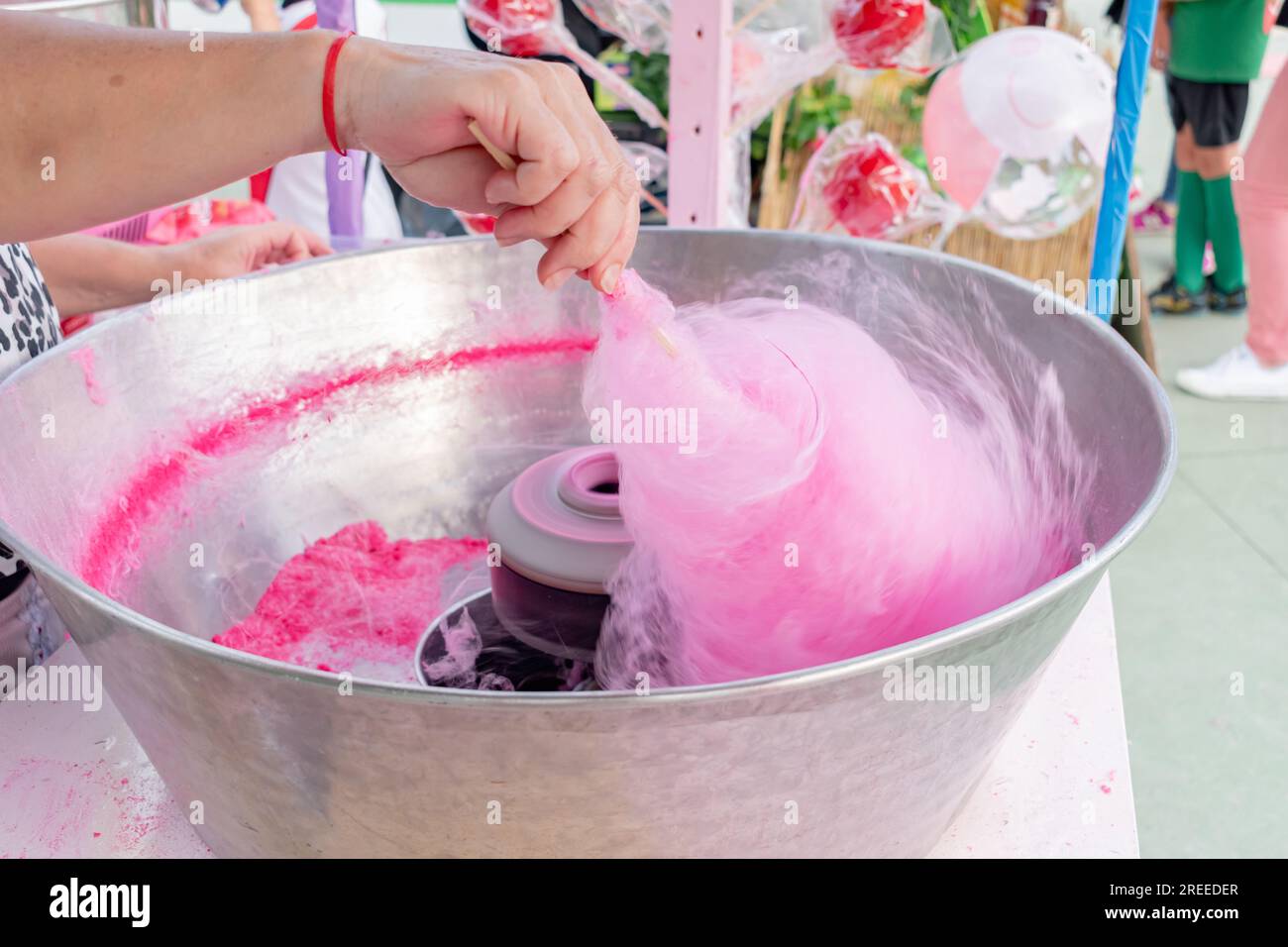Woman making pink cotton candy at a street fair food stall Stock Photo ...