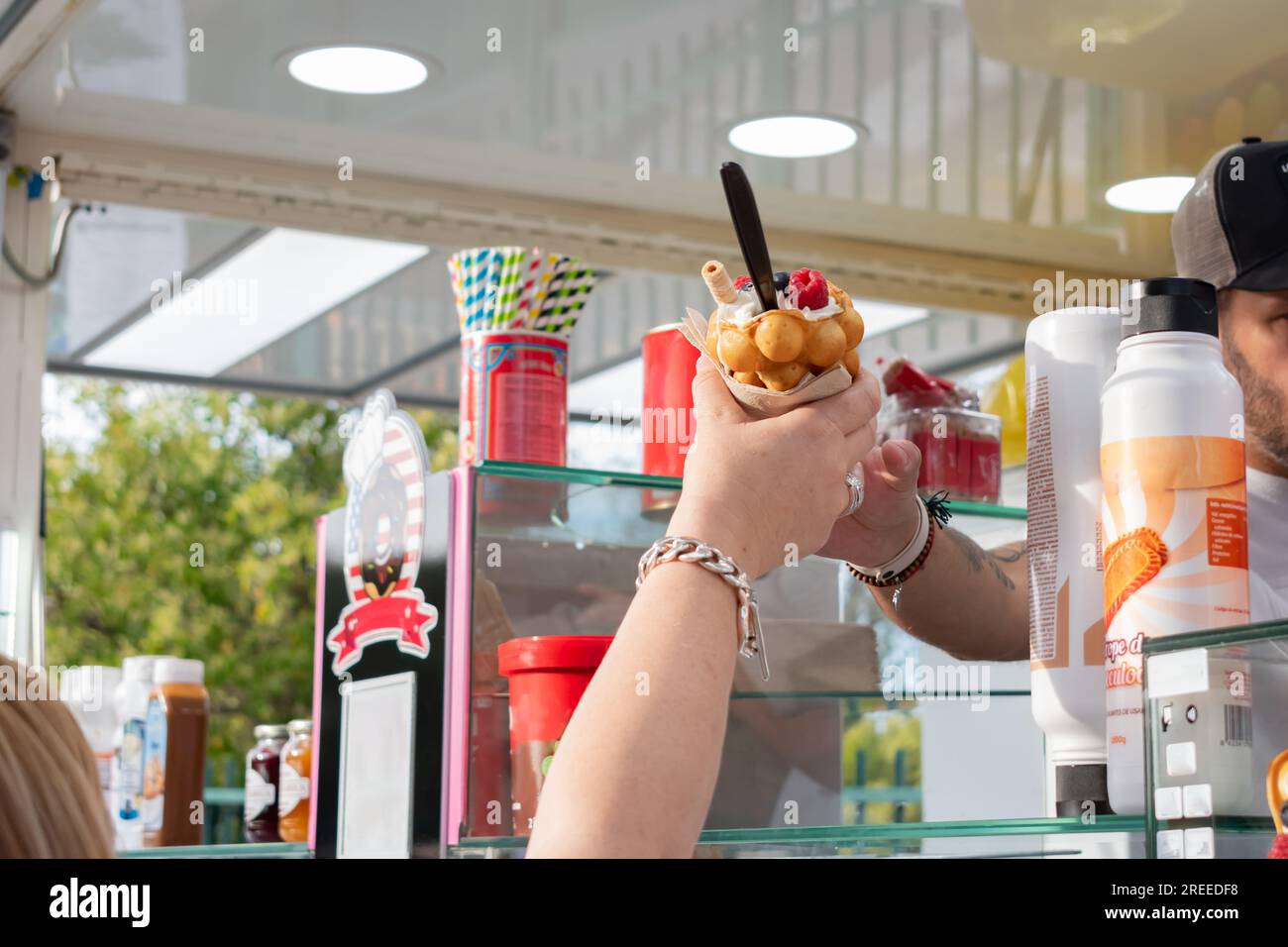 Customer receiving a waffle cone at a street food stall Stock Photo - Alamy
