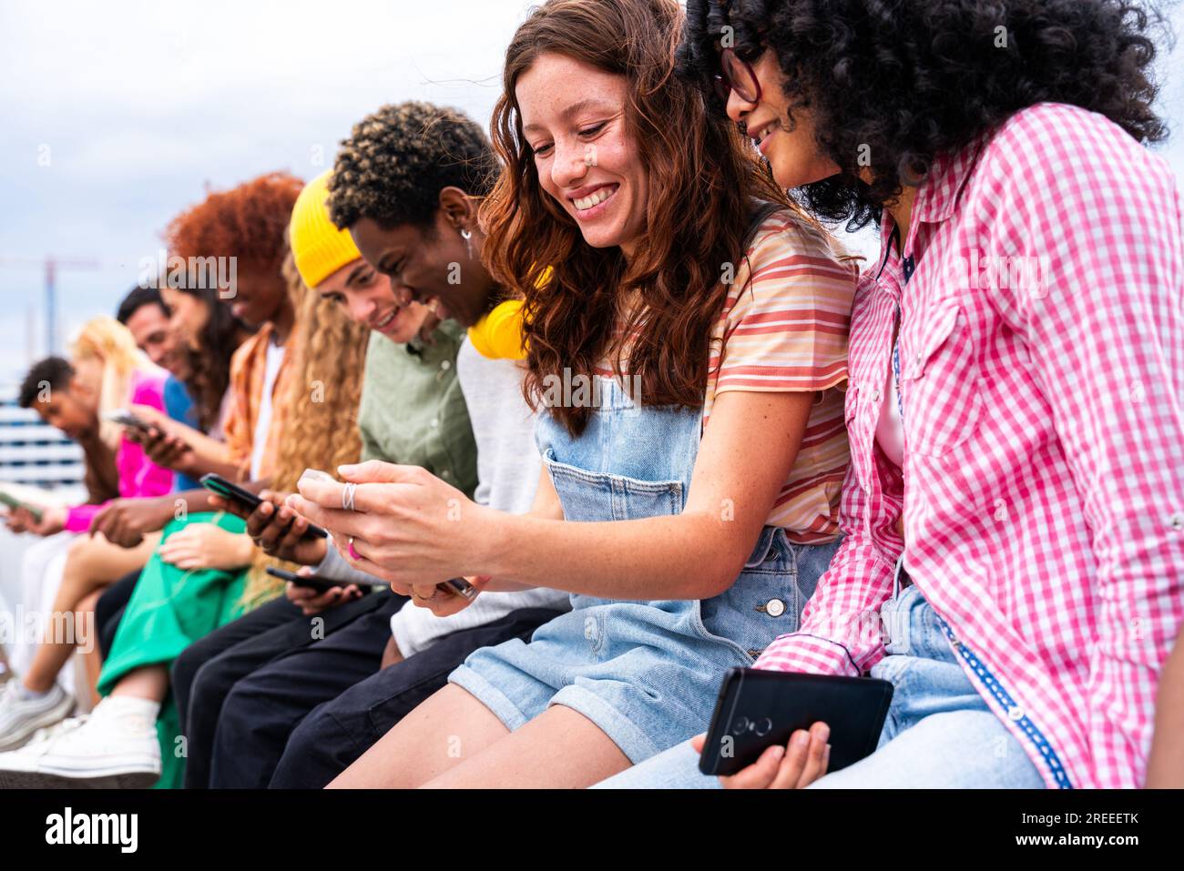 Happy playful multiethnic group of young friends bonding outdoors ...