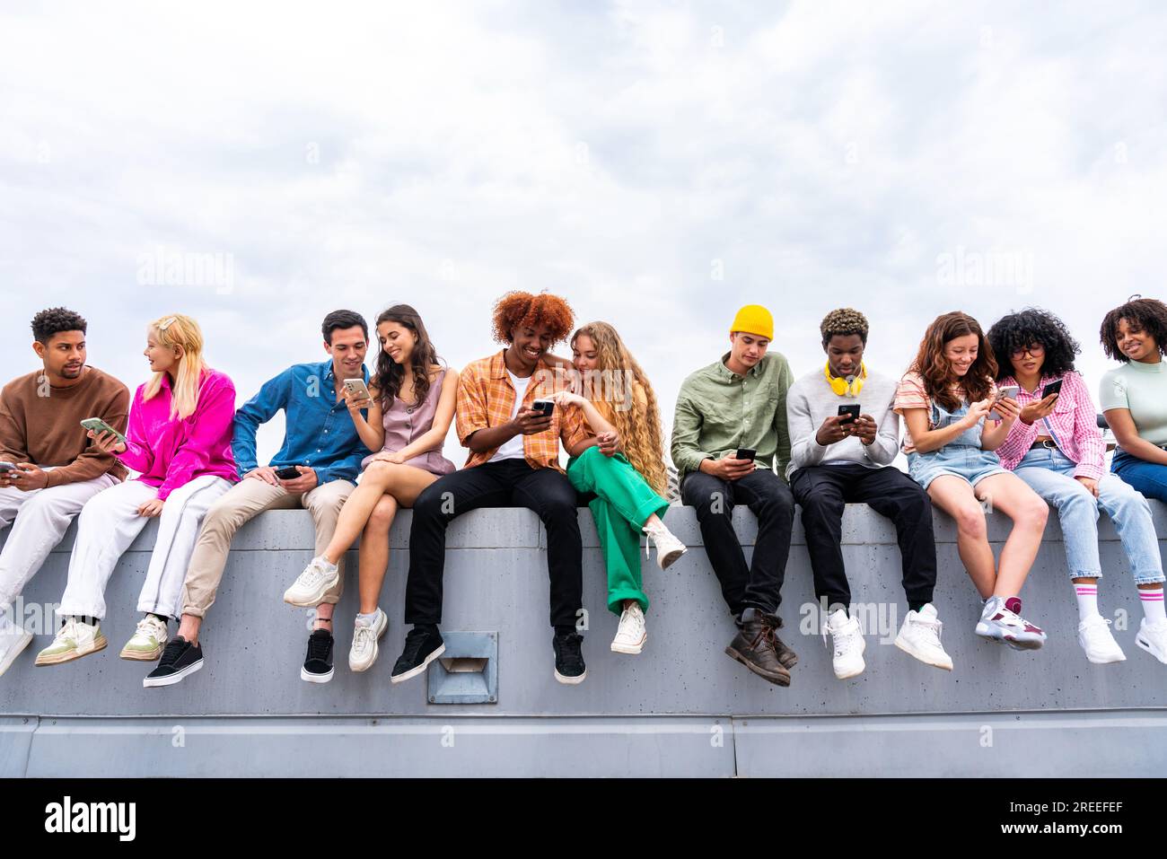 Happy playful multiethnic group of young friends bonding outdoors ...
