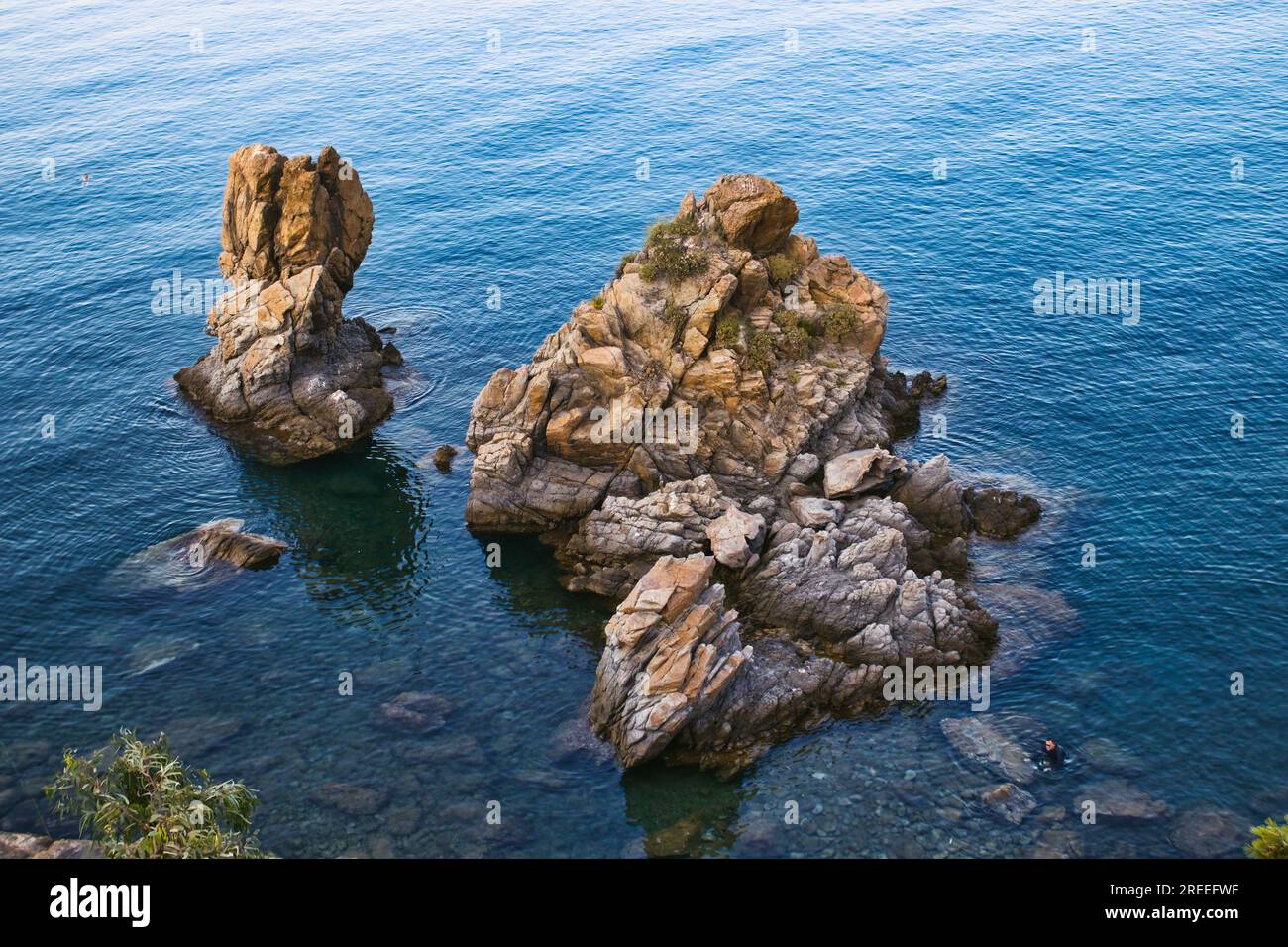Rocks jutting out of the sea at Spiaggia Caldura beach in Cefalu ...