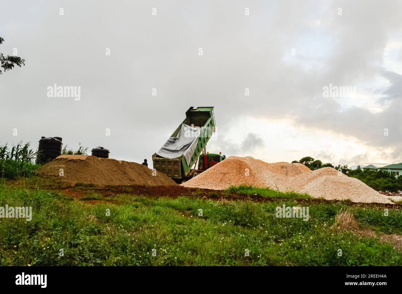 The tailgate of a green tipper body truck is left suspended on the two ...