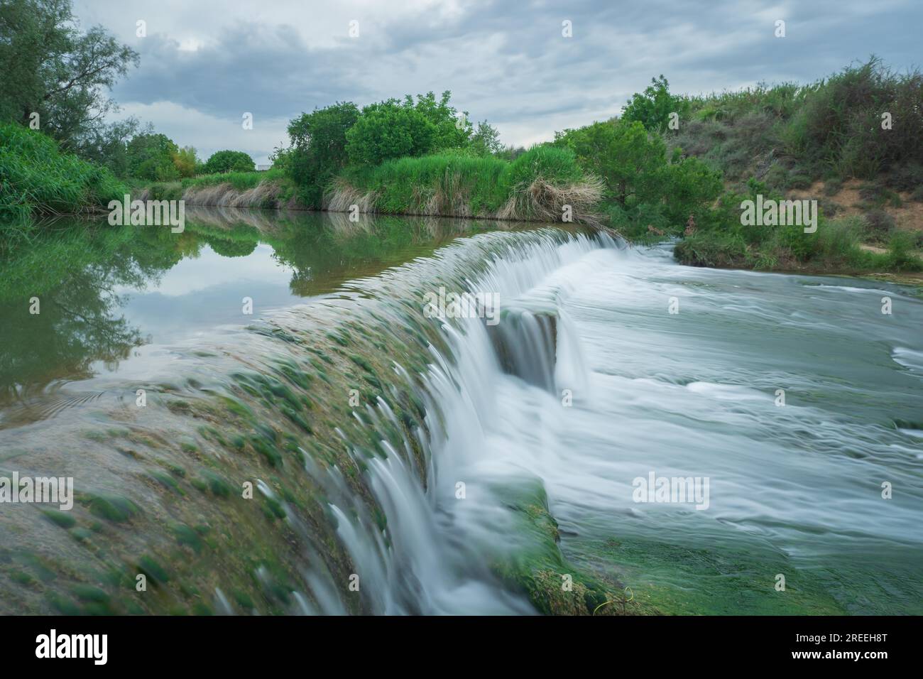 Waterfall in a dam of a mountain river of crystal clear waters with ...