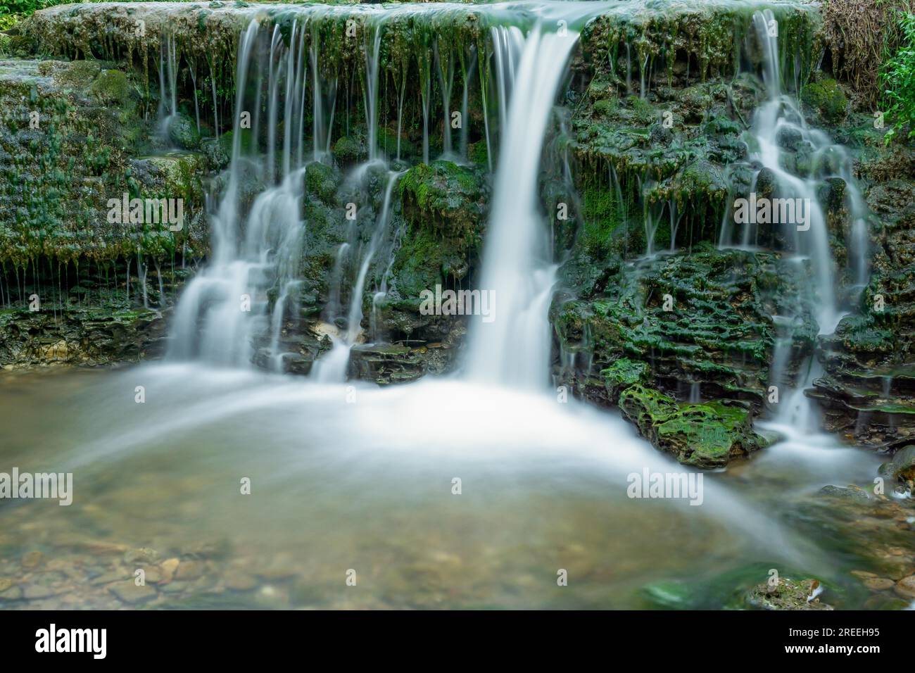 Waterfall in a mountain river of crystal clear waters with green ...