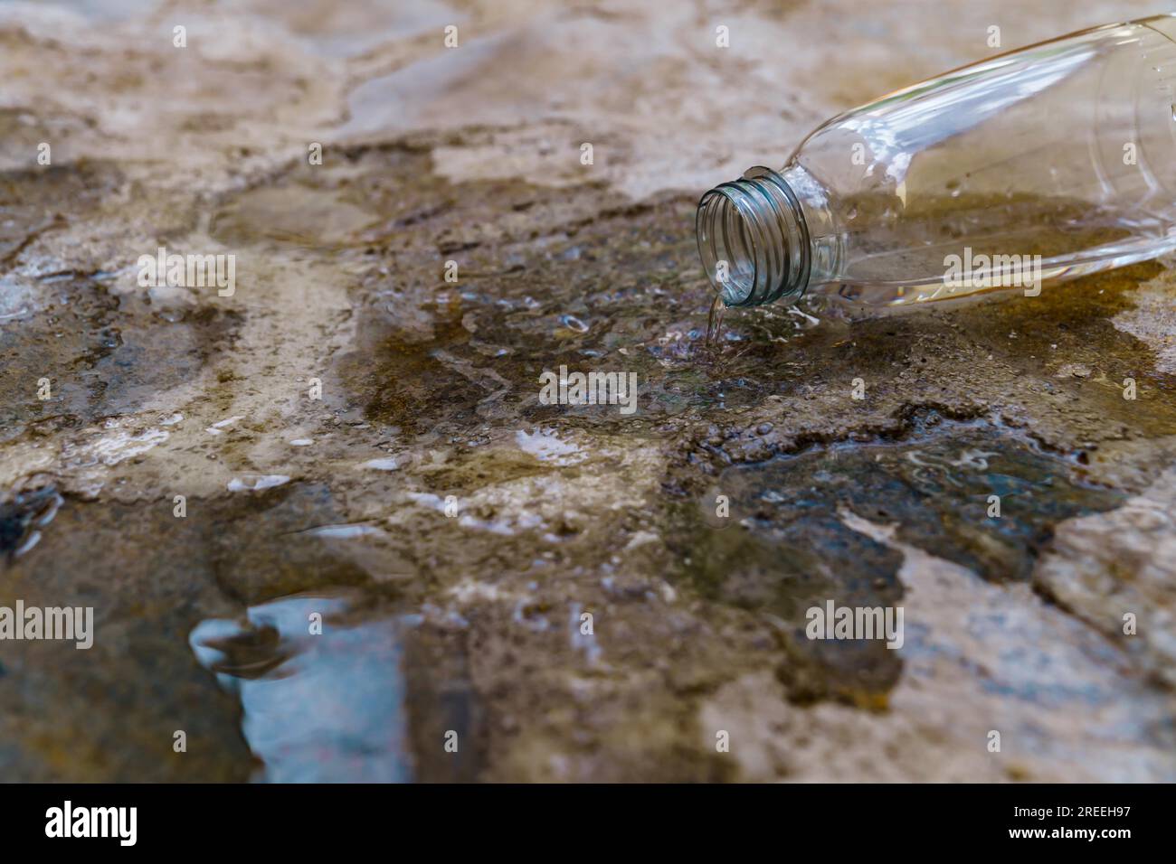 Close-up of a plastic water bottle spilling water on a flight of stairs ...