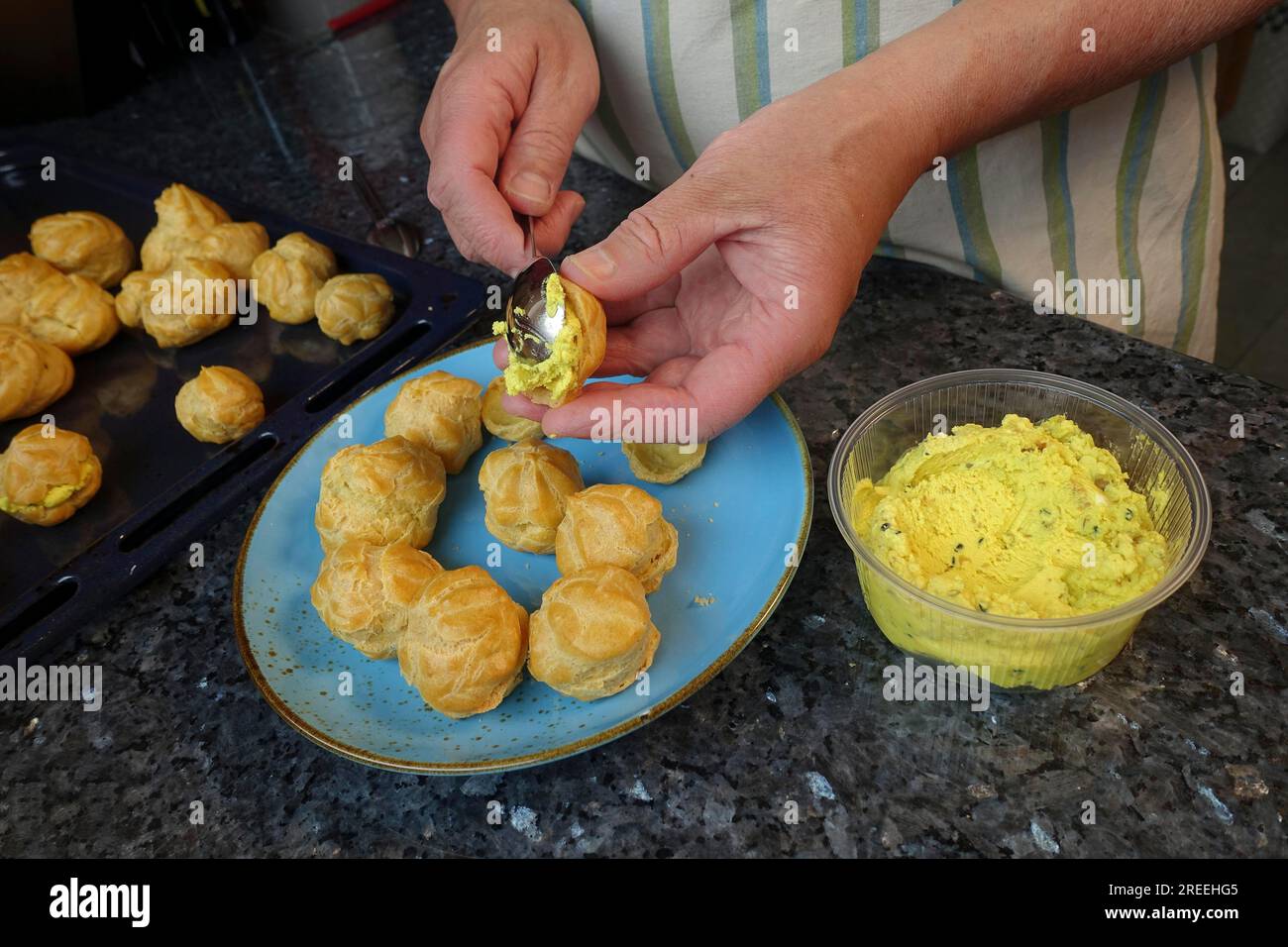 Swabian cuisine, preparing mini cream puffs, filling eclairs with cream ...