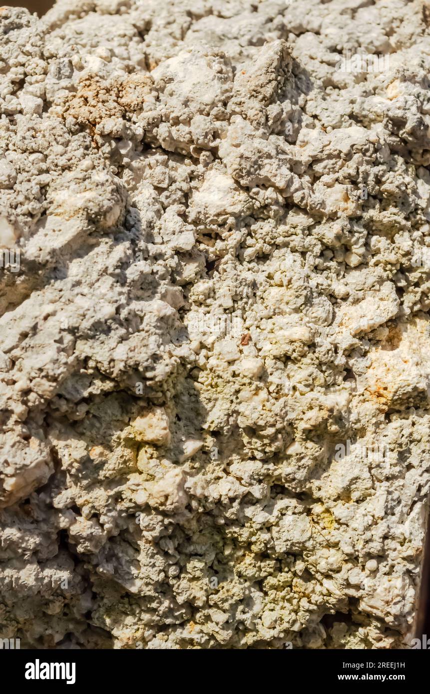 The sunlight hits the ridges of a rough concrete surface casting ...