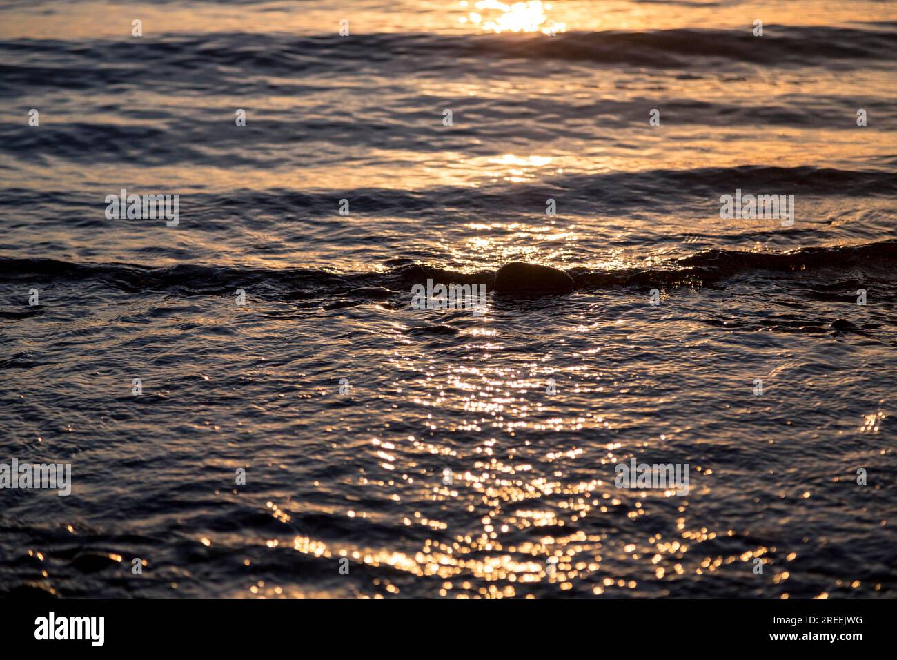 Ocean ripples at the sunset for backgrounds Stock Photo - Alamy