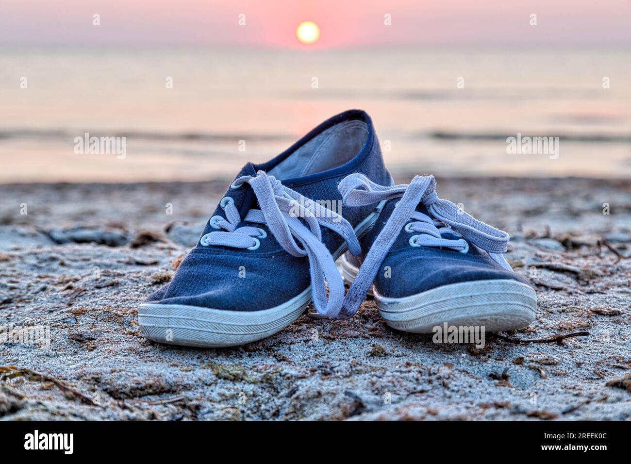 Two sneakers at the beach Stock Photo - Alamy
