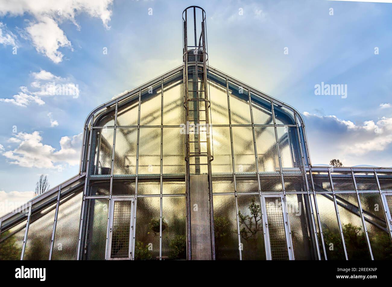 Glass house with the sun behind and dynamic sky Stock Photo - Alamy