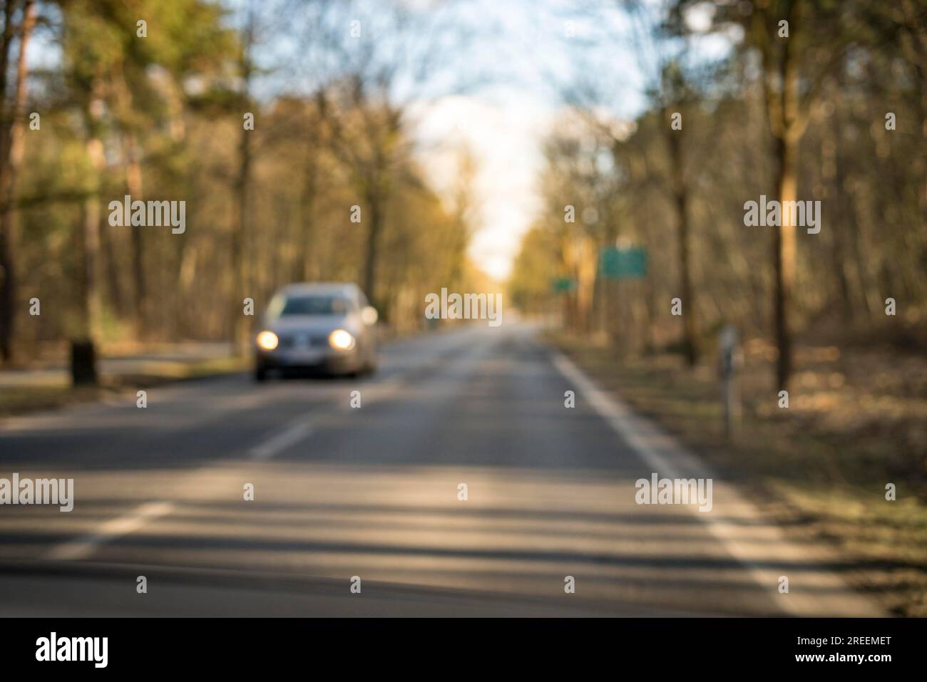Blurry street with car and forrest for backgrounds Stock Photo - Alamy