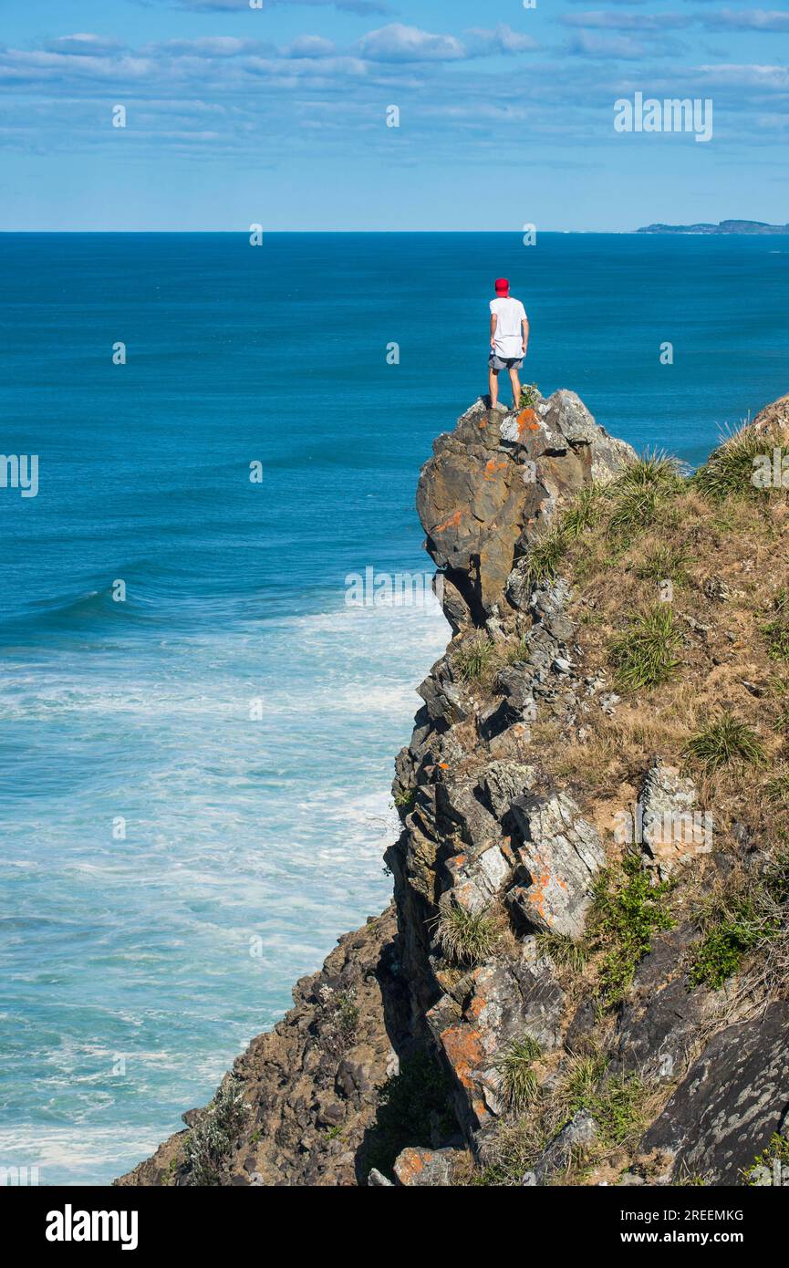 Man sitting on a rock on the cliffs on Cape Byron, Byron Bay ...