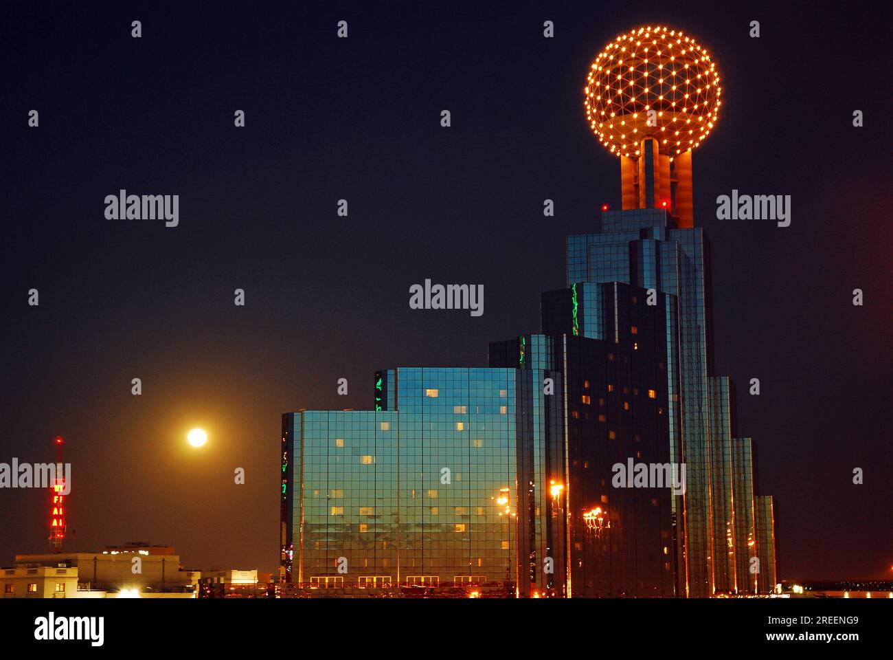 The full moon rises behind the Reunion Center and the skyline of Dallas ...
