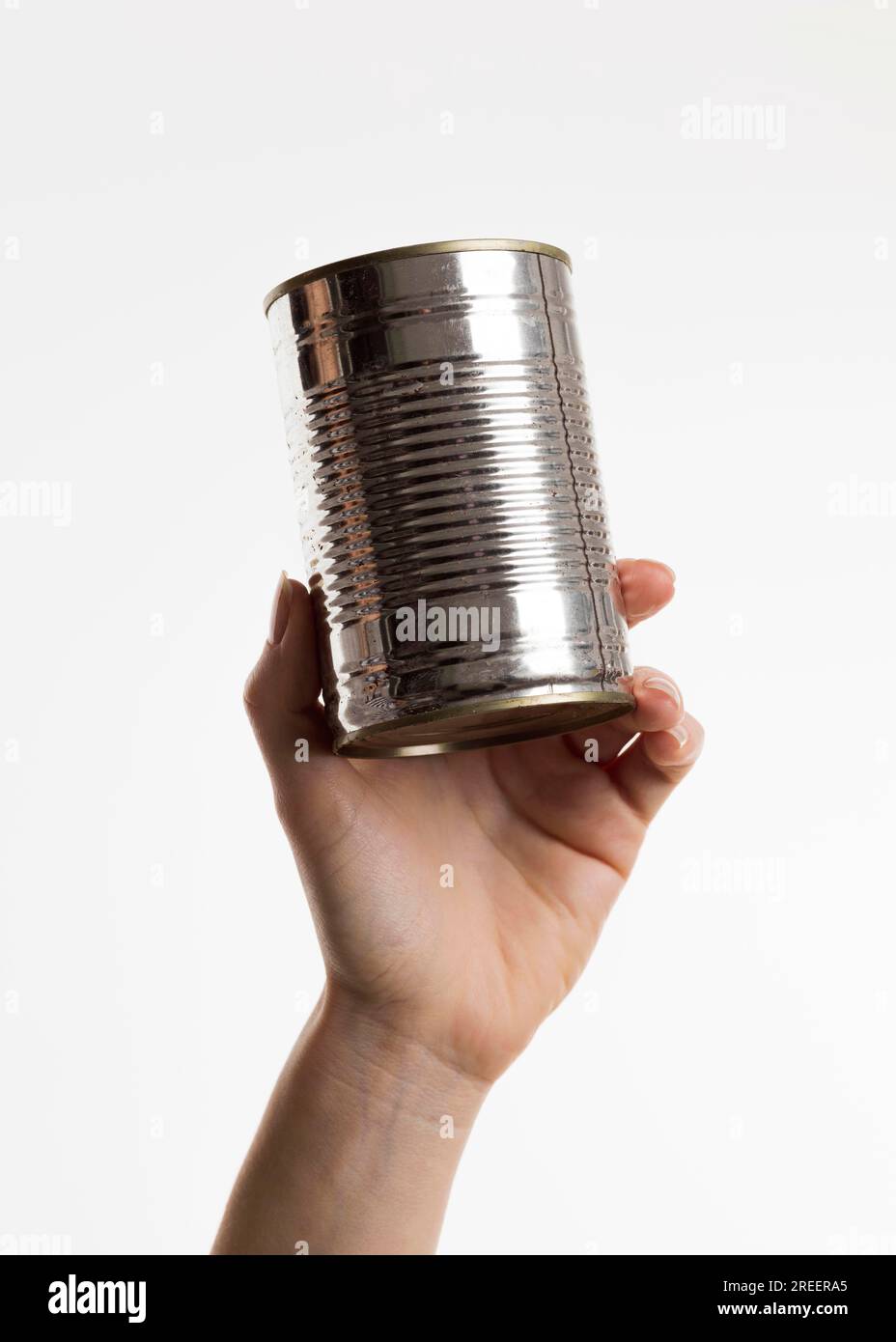Hand holding tin can Stock Photo - Alamy