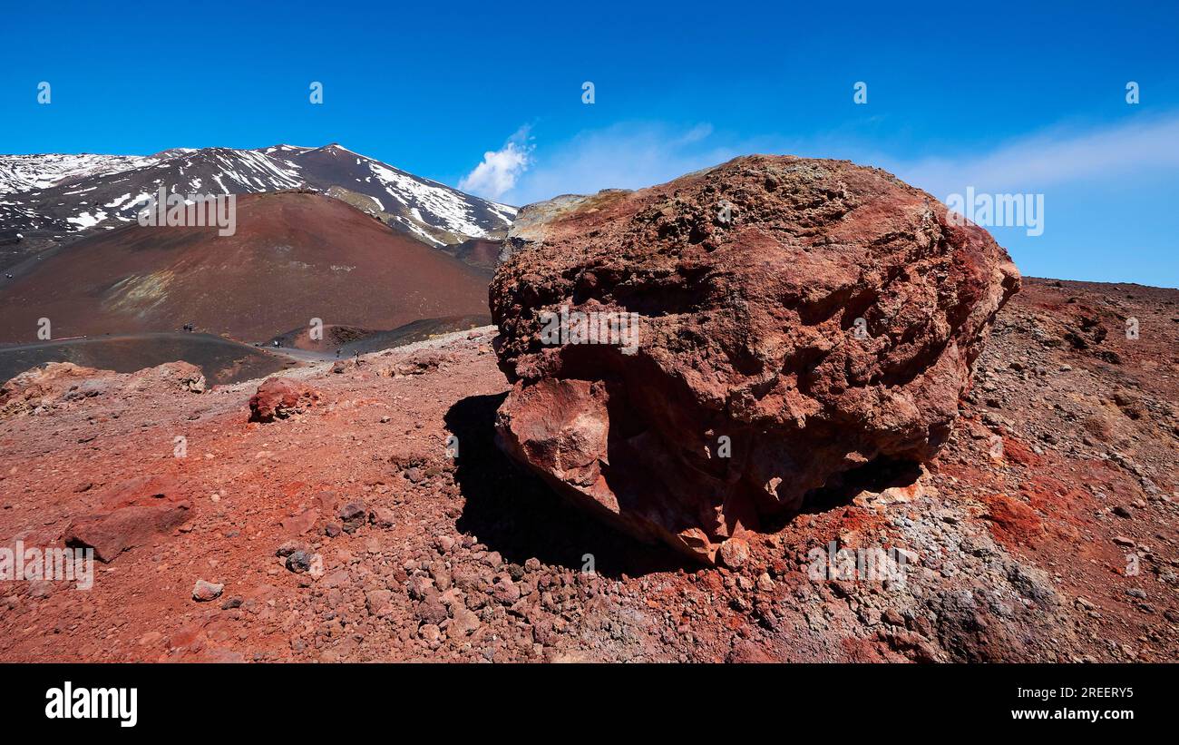 Big red lava rock, red lava earth, snowy peak, blue sky, white clouds ...