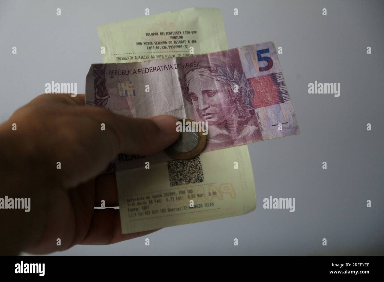 salvador, bahia, brazil - july 15, 2023: hand holds invoice with QR ...