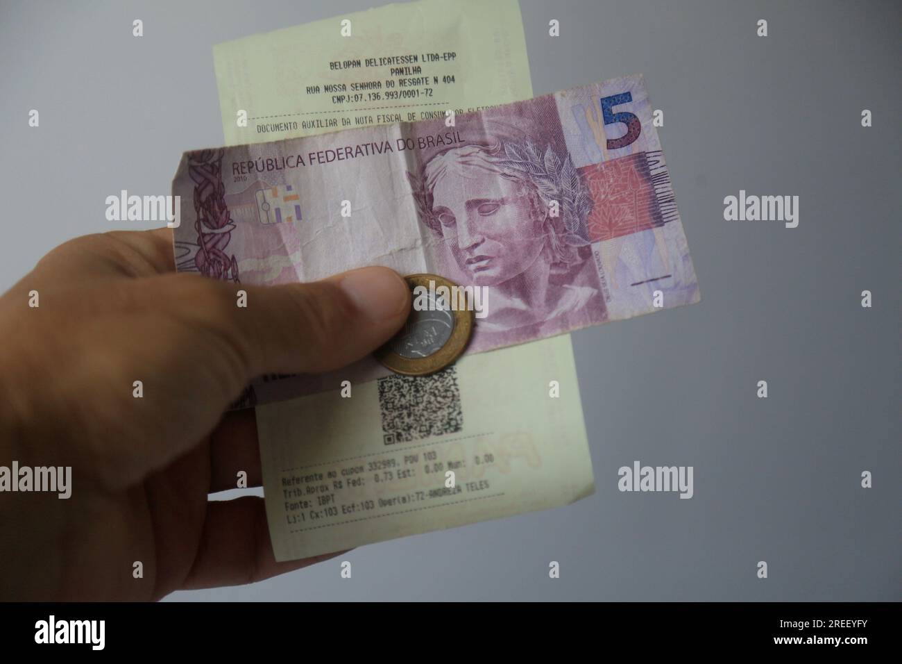 salvador, bahia, brazil - july 15, 2023: hand holds invoice with QR ...