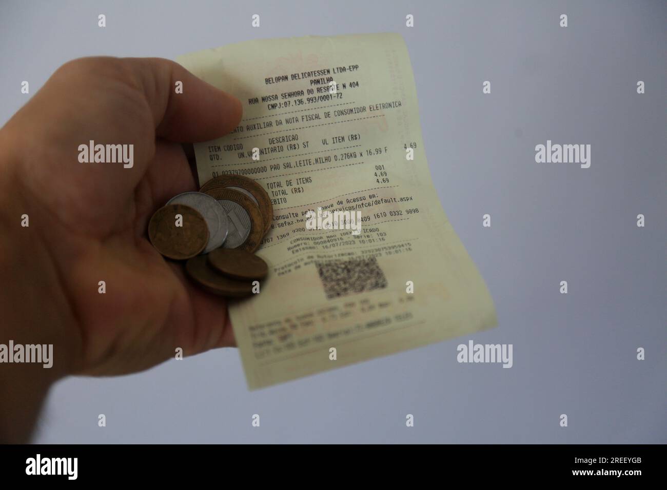 salvador, bahia, brazil - july 15, 2023: hand holds invoice with QR ...